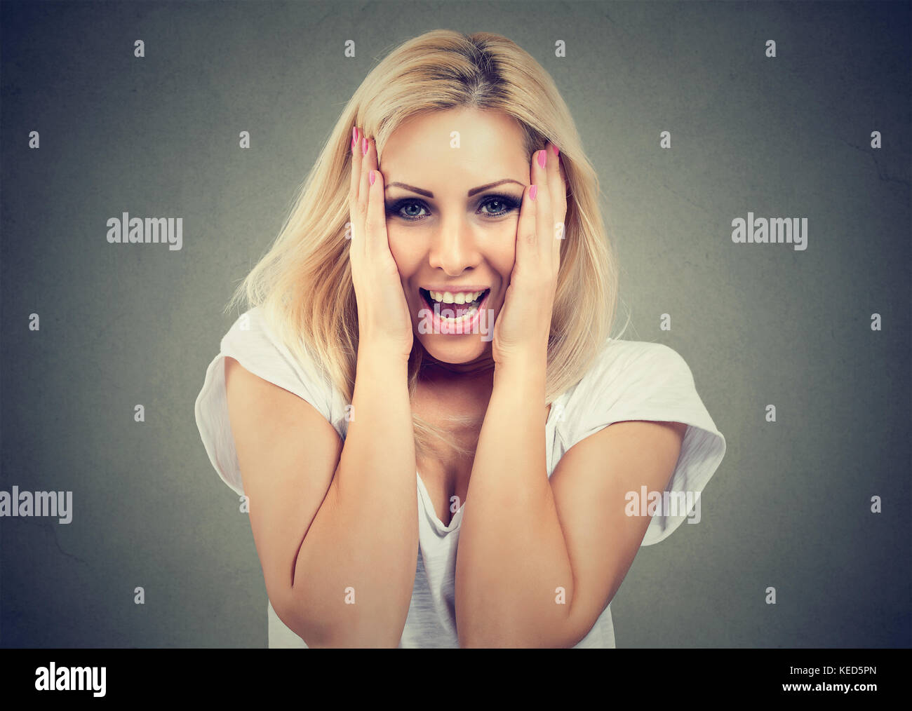 Surprised young woman smiling in studio Stock Photo - Alamy