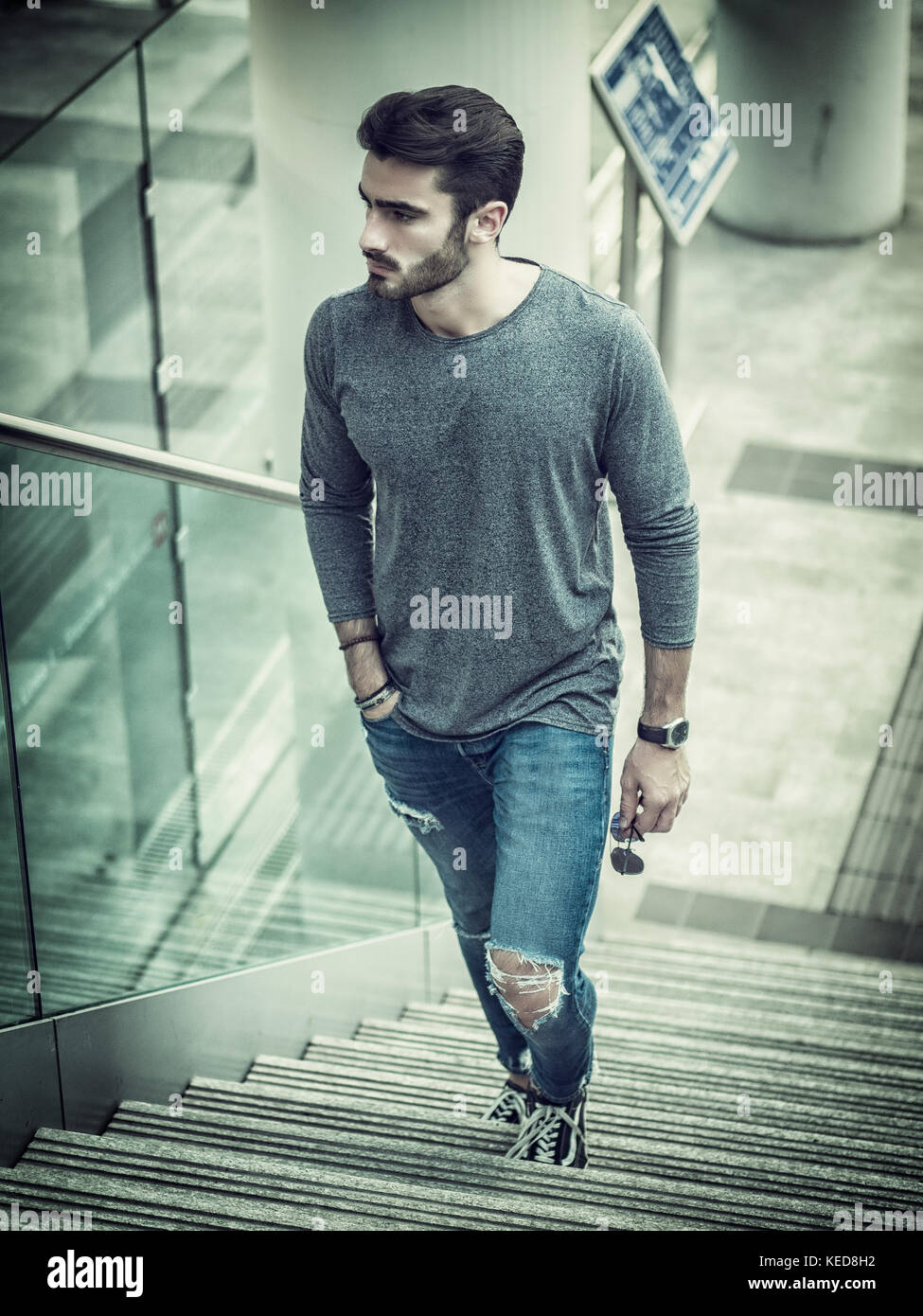 Handsome young man walking on stairway Stock Photo - Alamy