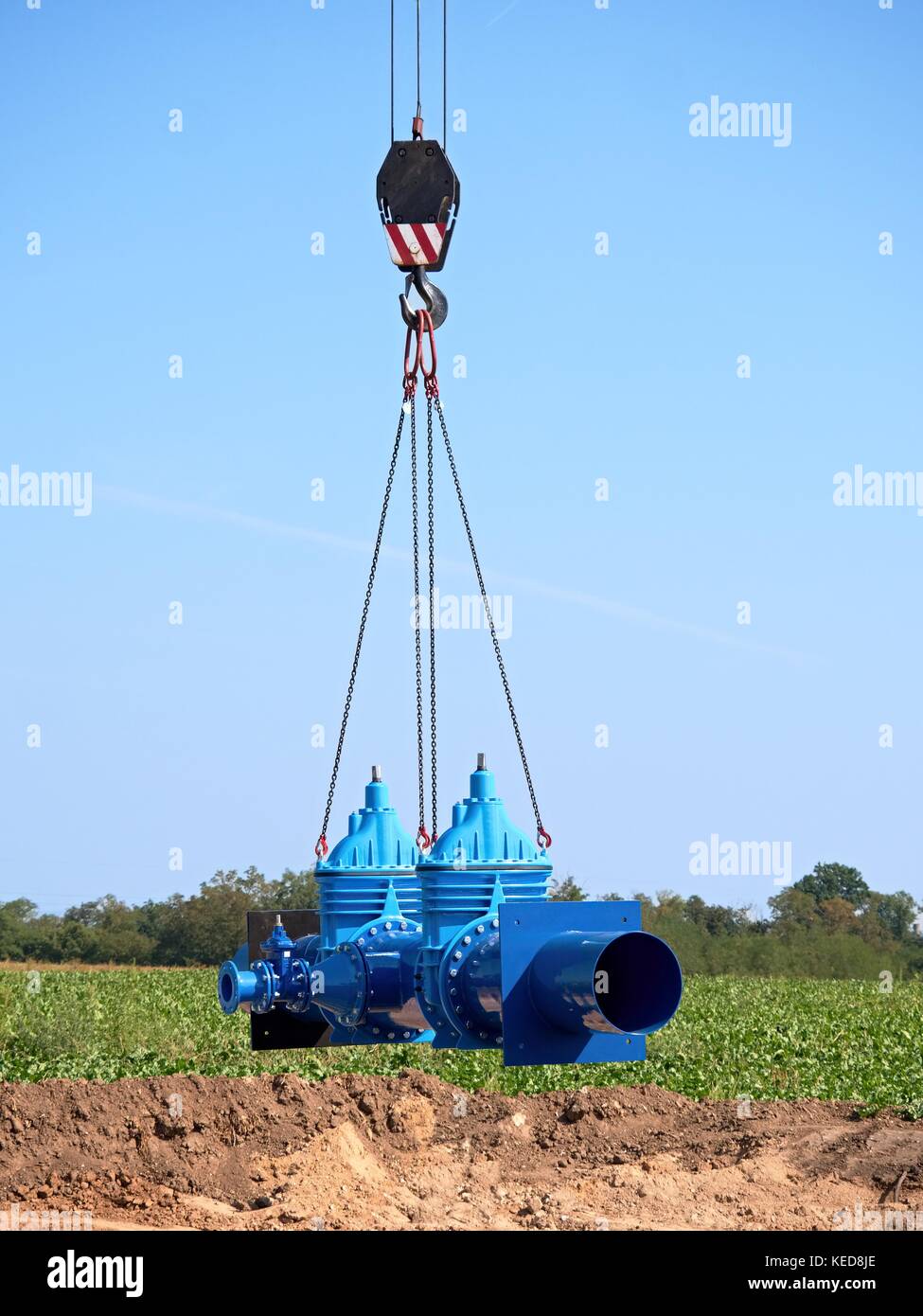 Crane handling 500mm pipe with gate valves. Construction process to ...