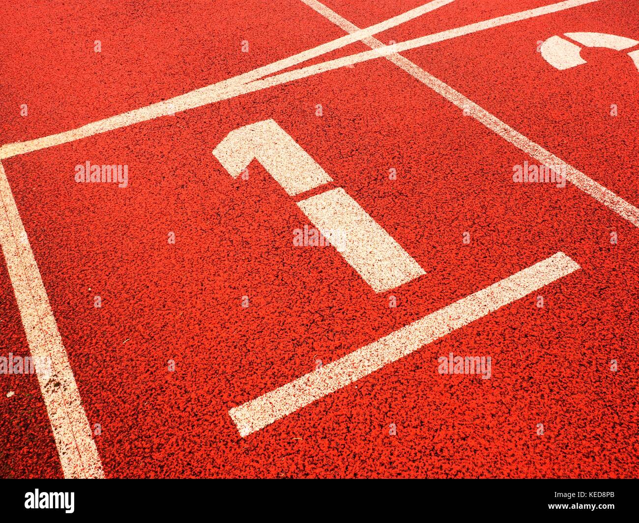 Number one. White track number on red rubber racetrack, texture of ...