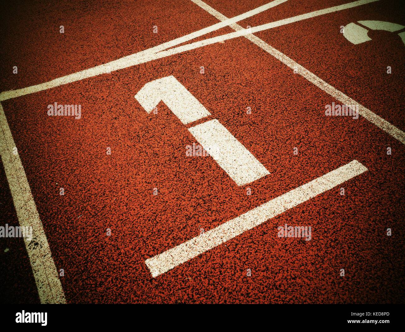 Number one. White track number on red rubber racetrack, texture of ...