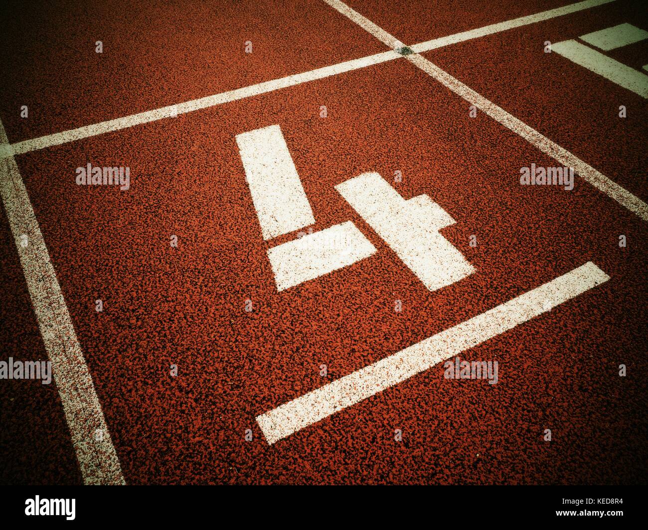 Number four. White track number on red rubber racetrack, texture of ...