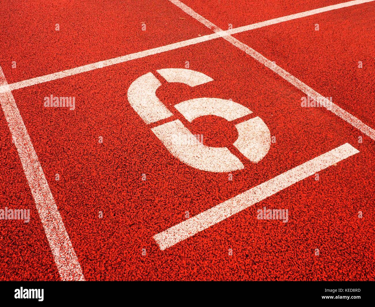 Number six. White athletic track number on red rubber racetrack ...