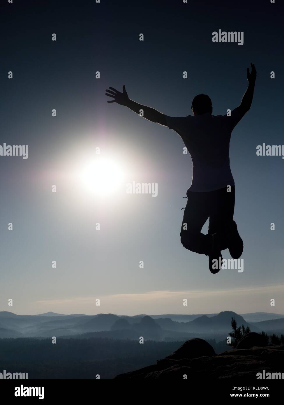 Jumping man. Young crazy man is jumping on colorful sky background ...