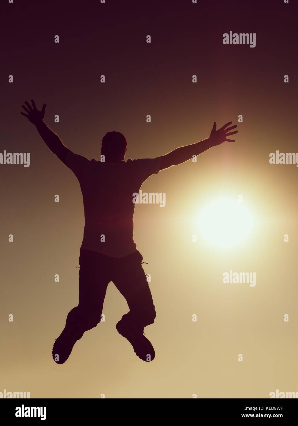 Jumping man. Young crazy man is jumping on red sky background ...