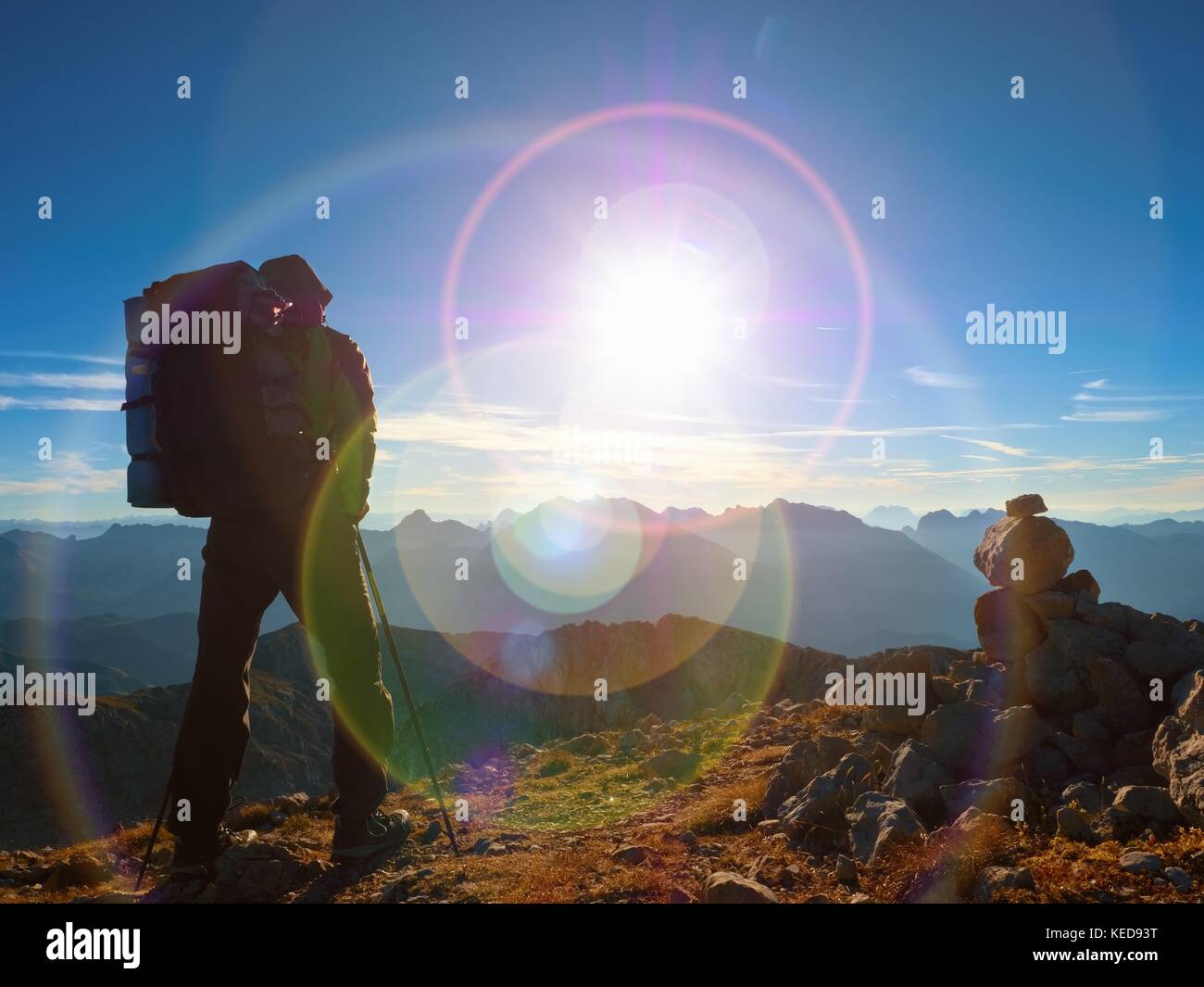 Lens flare light, strong defect. Man hiker with rucksack walk on rocky ...