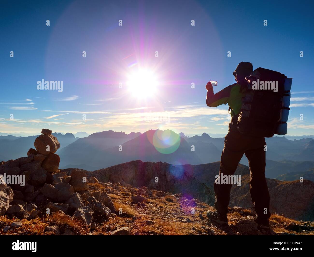 Lens flare light, strong defect. Tourist guide on Alps peak takes photo ...