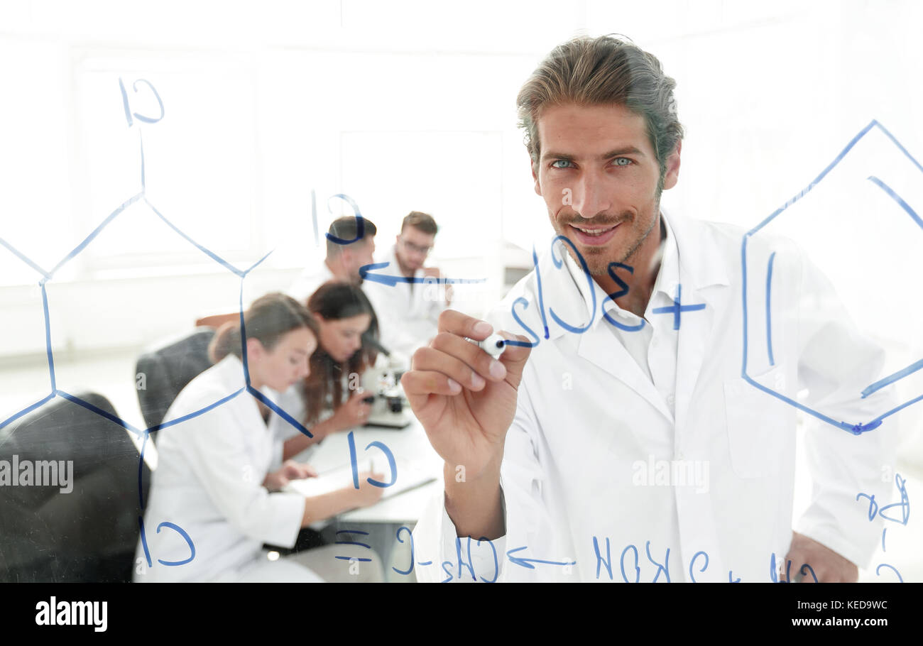 smiling scientist records data on a glass Board Stock Photo - Alamy