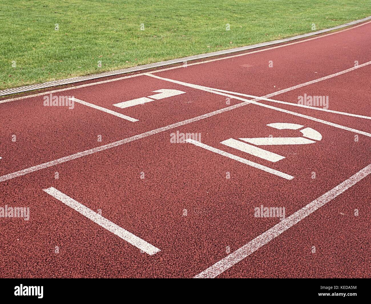 White track number on red rubber racetrack, texture of running ...