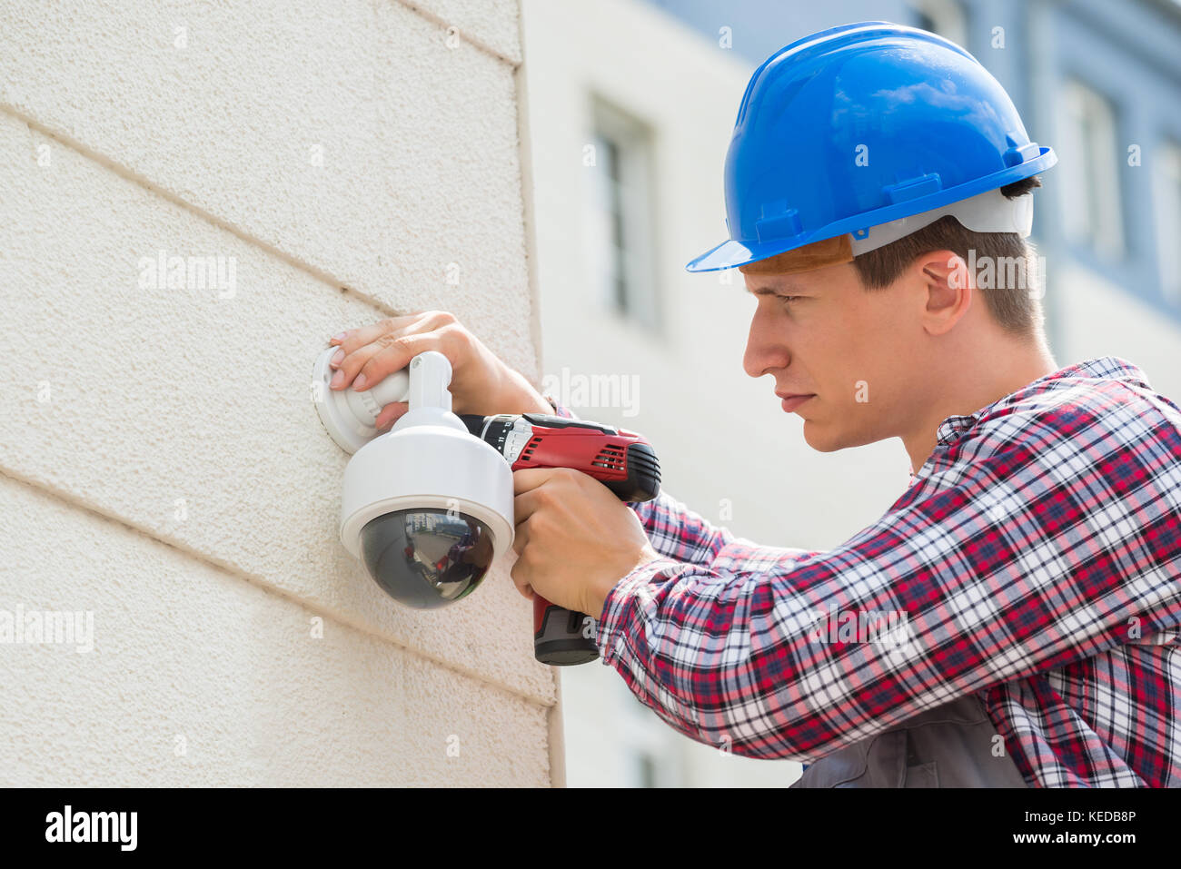 Young Male Technician Installing Camera On Wall Using Electric Cordless ...