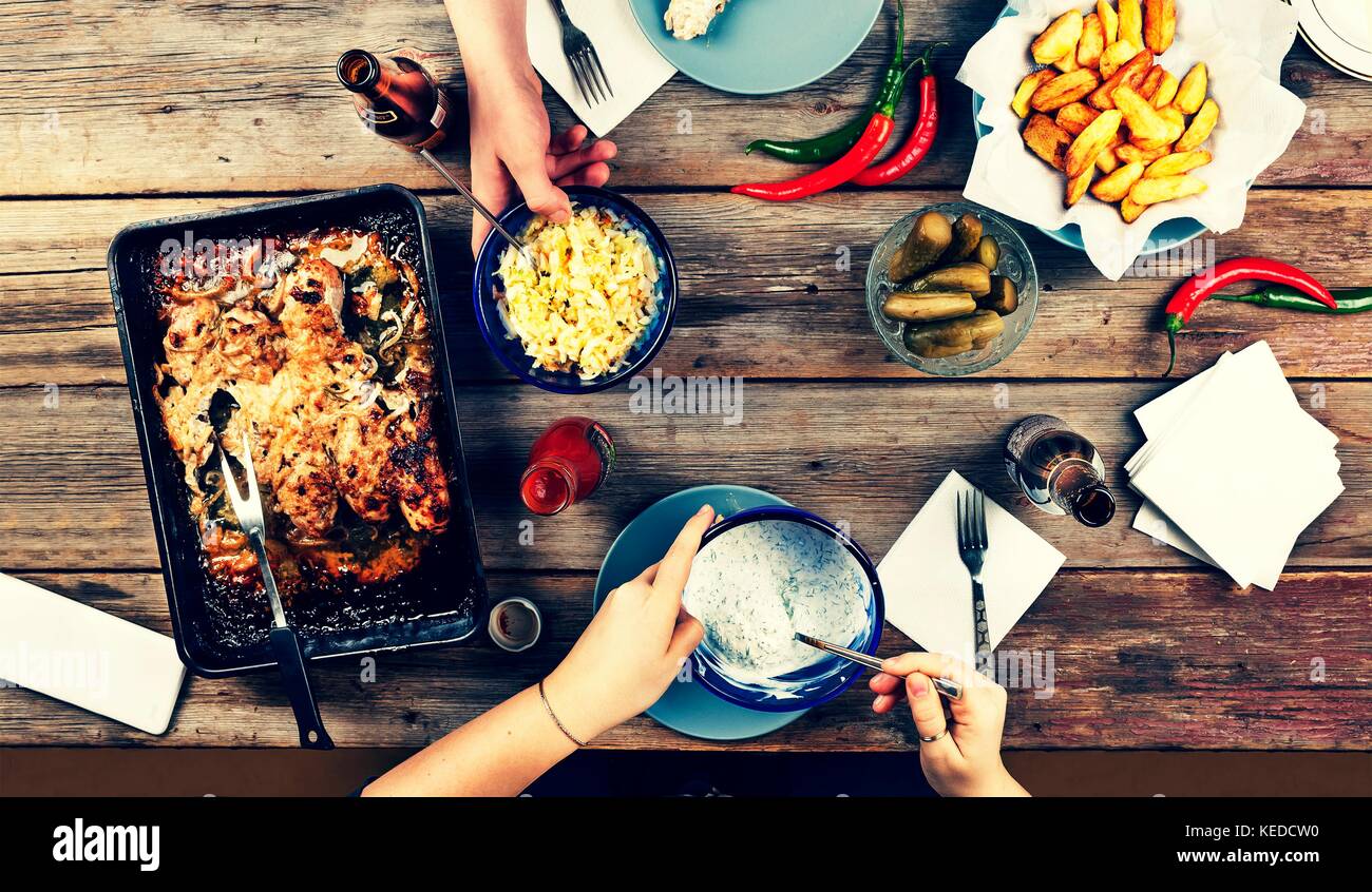 Couple of young people at the dinner table with a variety of foods ...