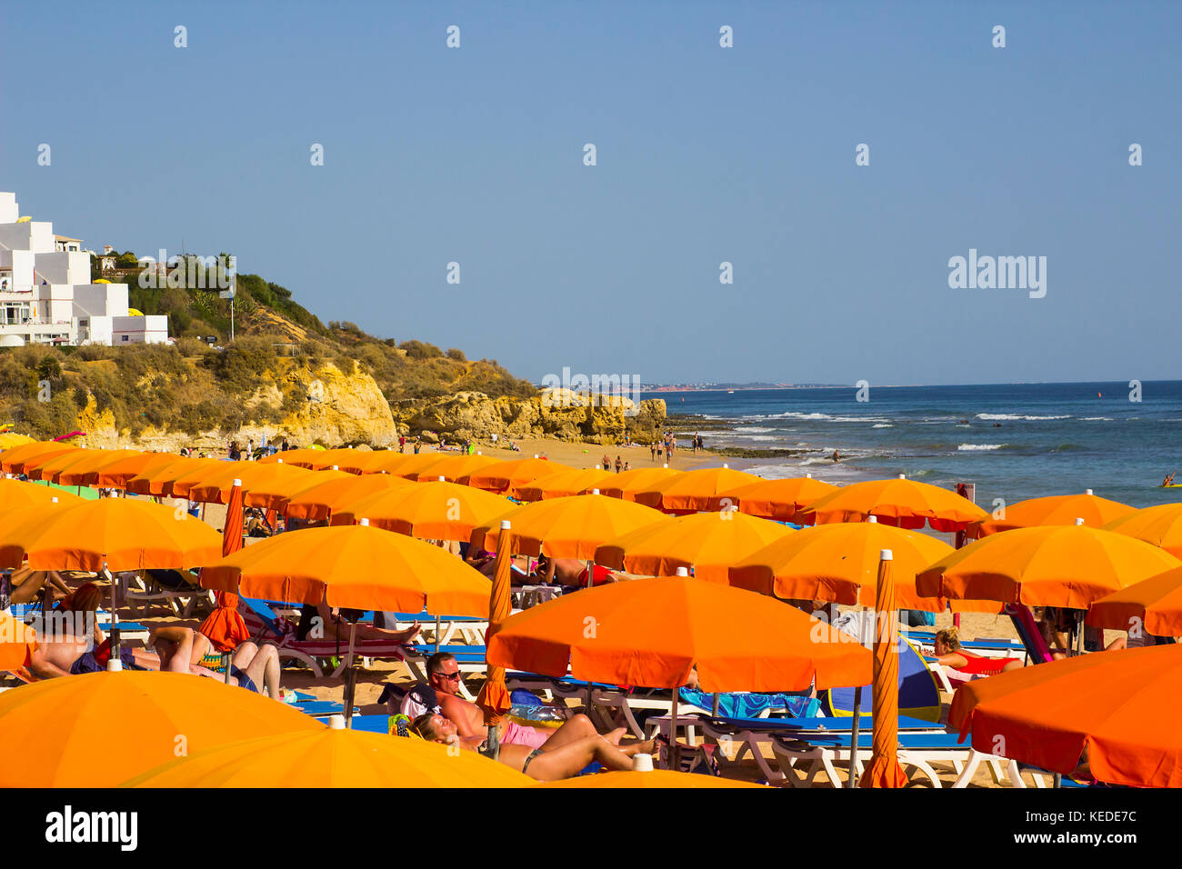 Dozens of brightly coloured sun beds and beach umbrellas on the sandy ...