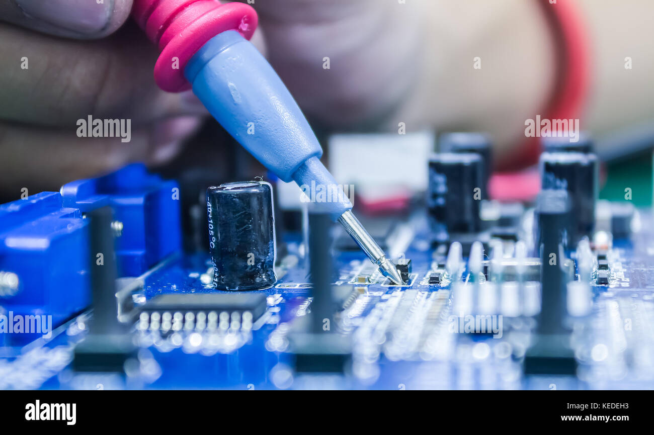 Using a multimeter in electronic circuit board on blue background Stock ...