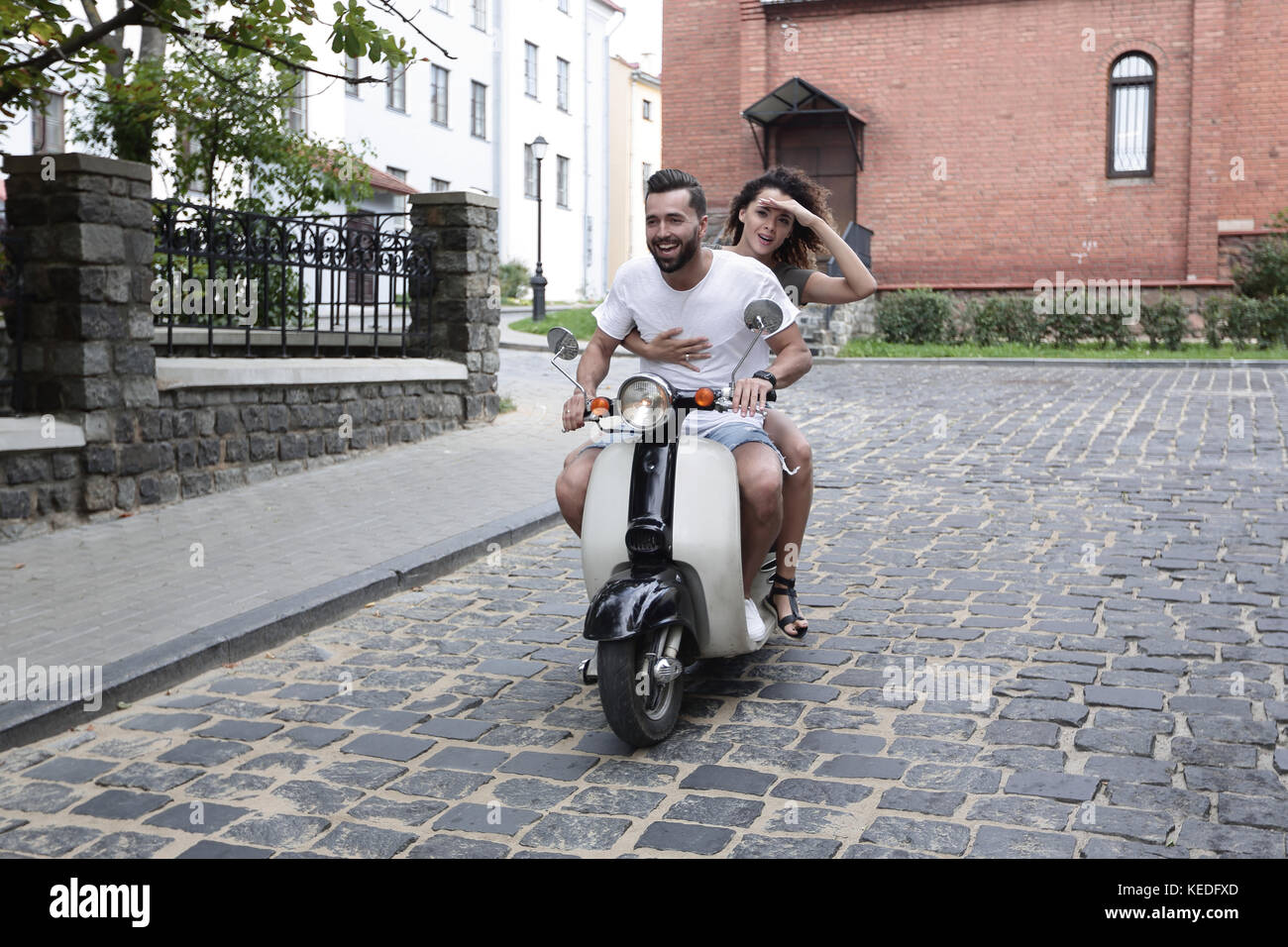 Young couple riding motor scooter in city Stock Photo - Alamy