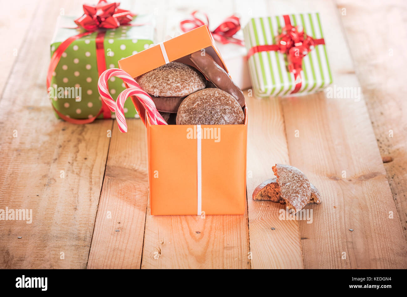 Top open gift box full of gingerbread and colorful candies on a wooden ...