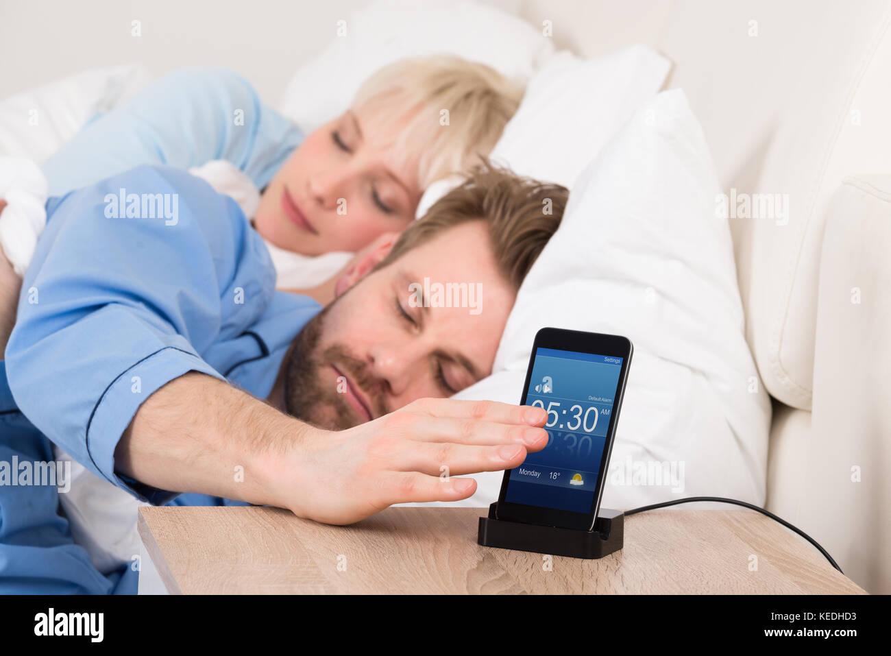 Man On Bed Snoozing Alarm Clock On Cell Phone Screen While Sleeping ...