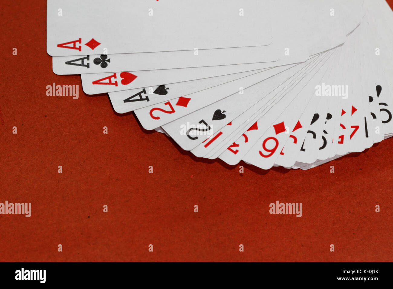 Playing card games on red background Stock Photo - Alamy