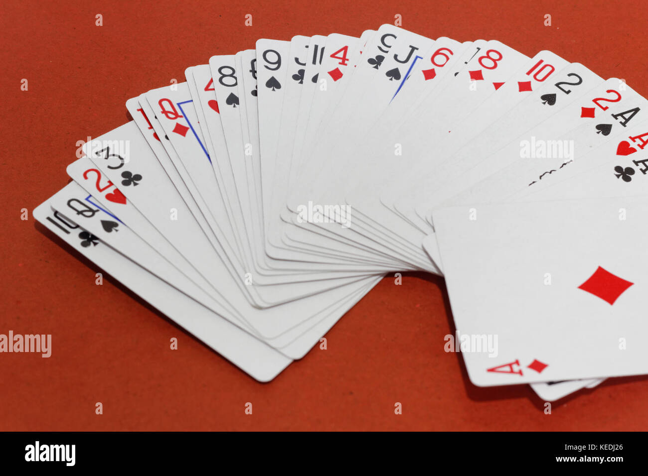 Playing card games on red background Stock Photo - Alamy