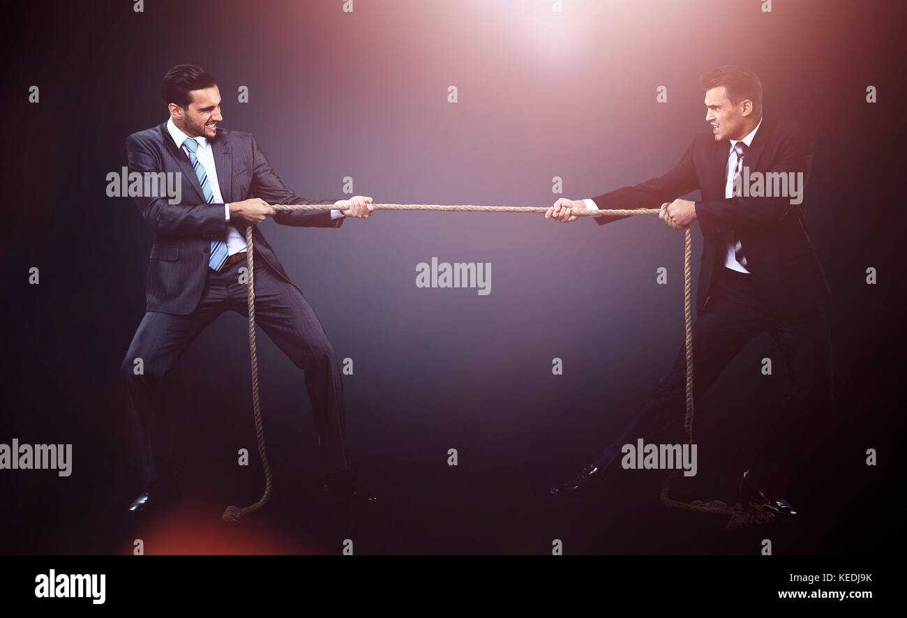 Two business men pulling rope in a competition Stock Photo - Alamy