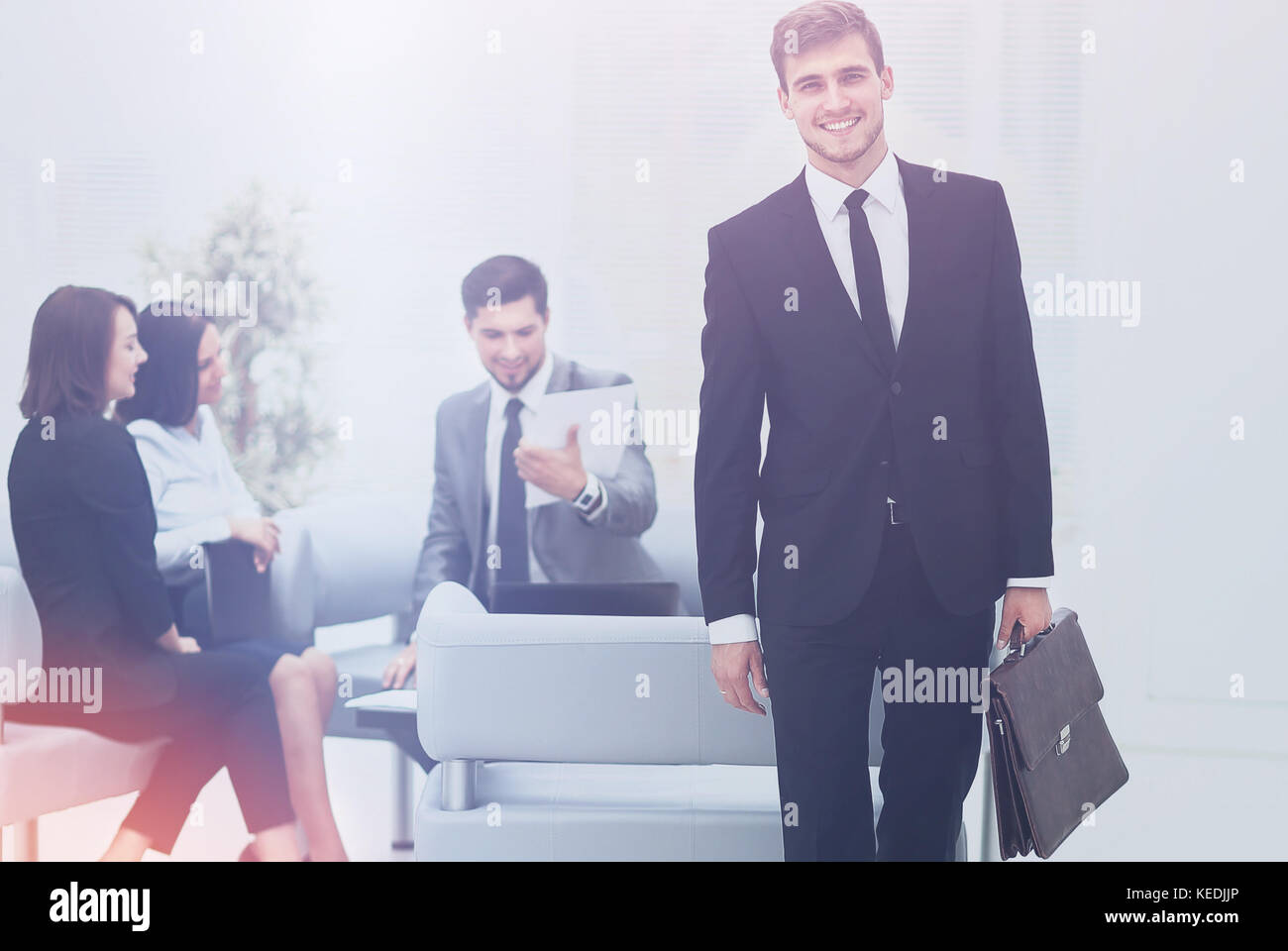 Successful business man standing with his staff in background at Stock ...