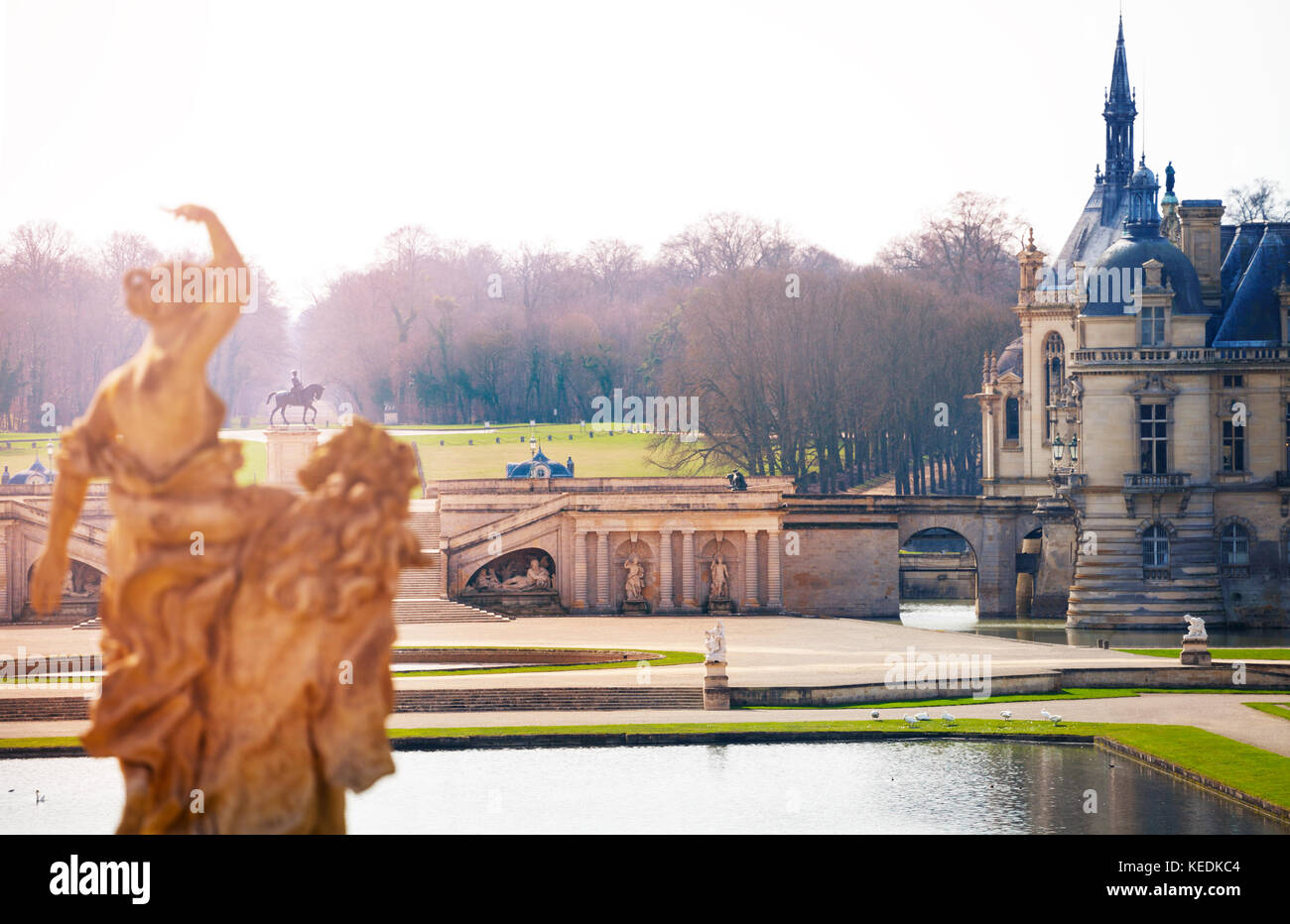 Romantic view of the Chateau de Chantilly castle surrounded by trees of ...