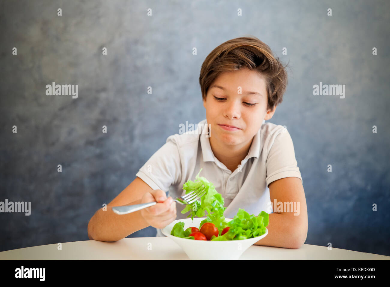 Portrait of teen boy refuses to eat salad Stock Photo - Alamy