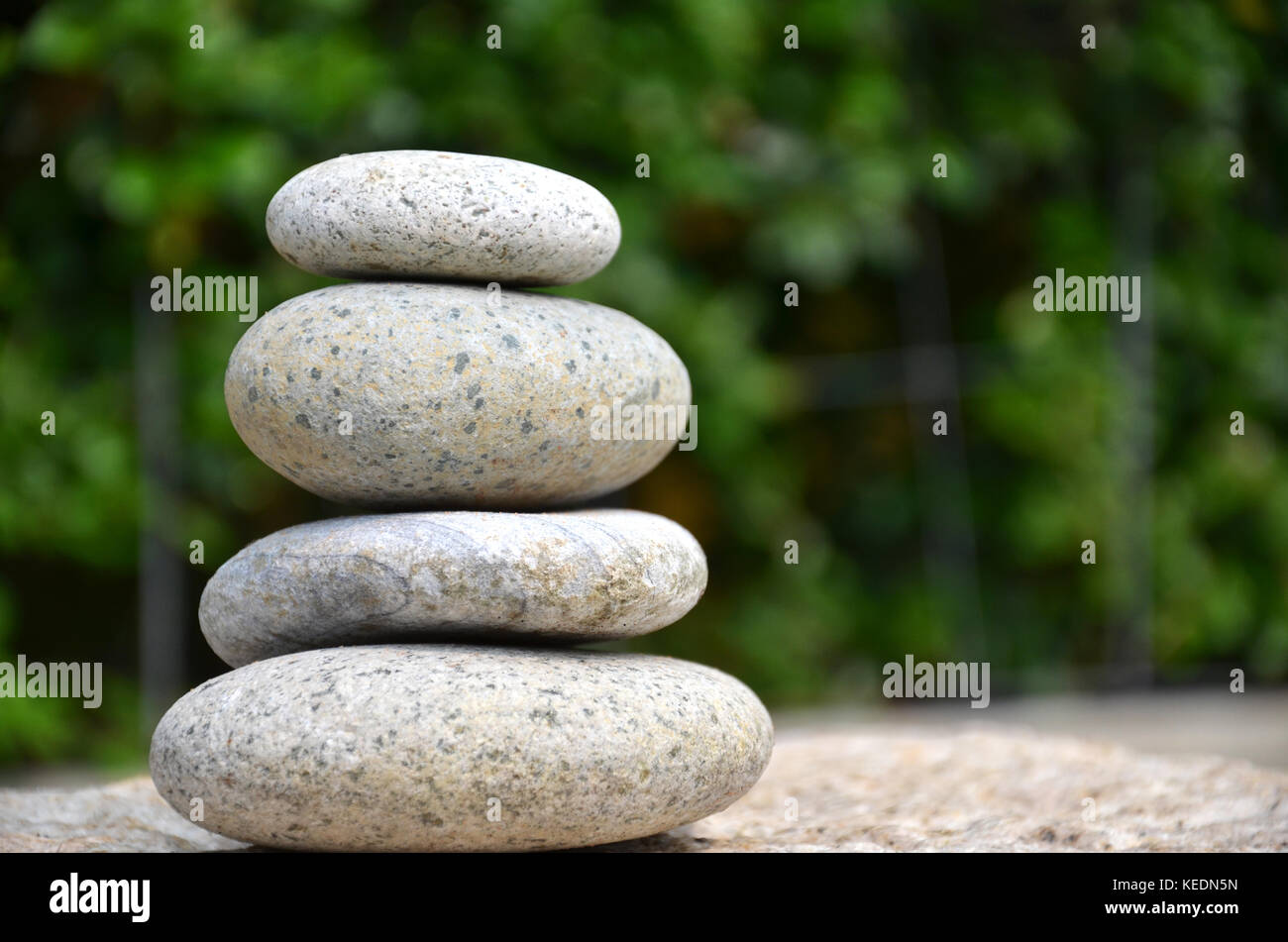 Stack of zen rocks in garden on green background Stock Photo - Alamy