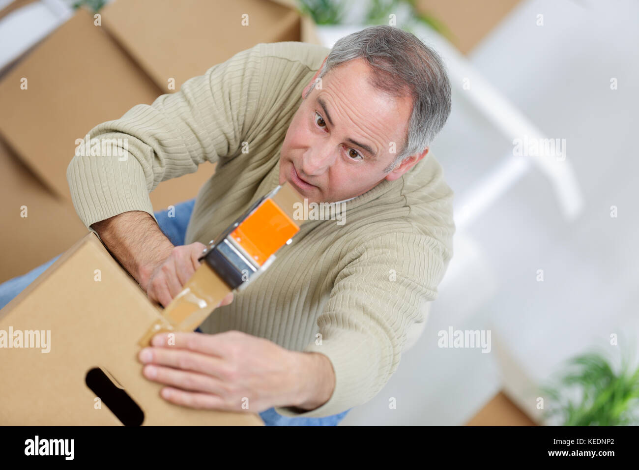 man packing a moving box using an adhesive tape Stock Photo - Alamy