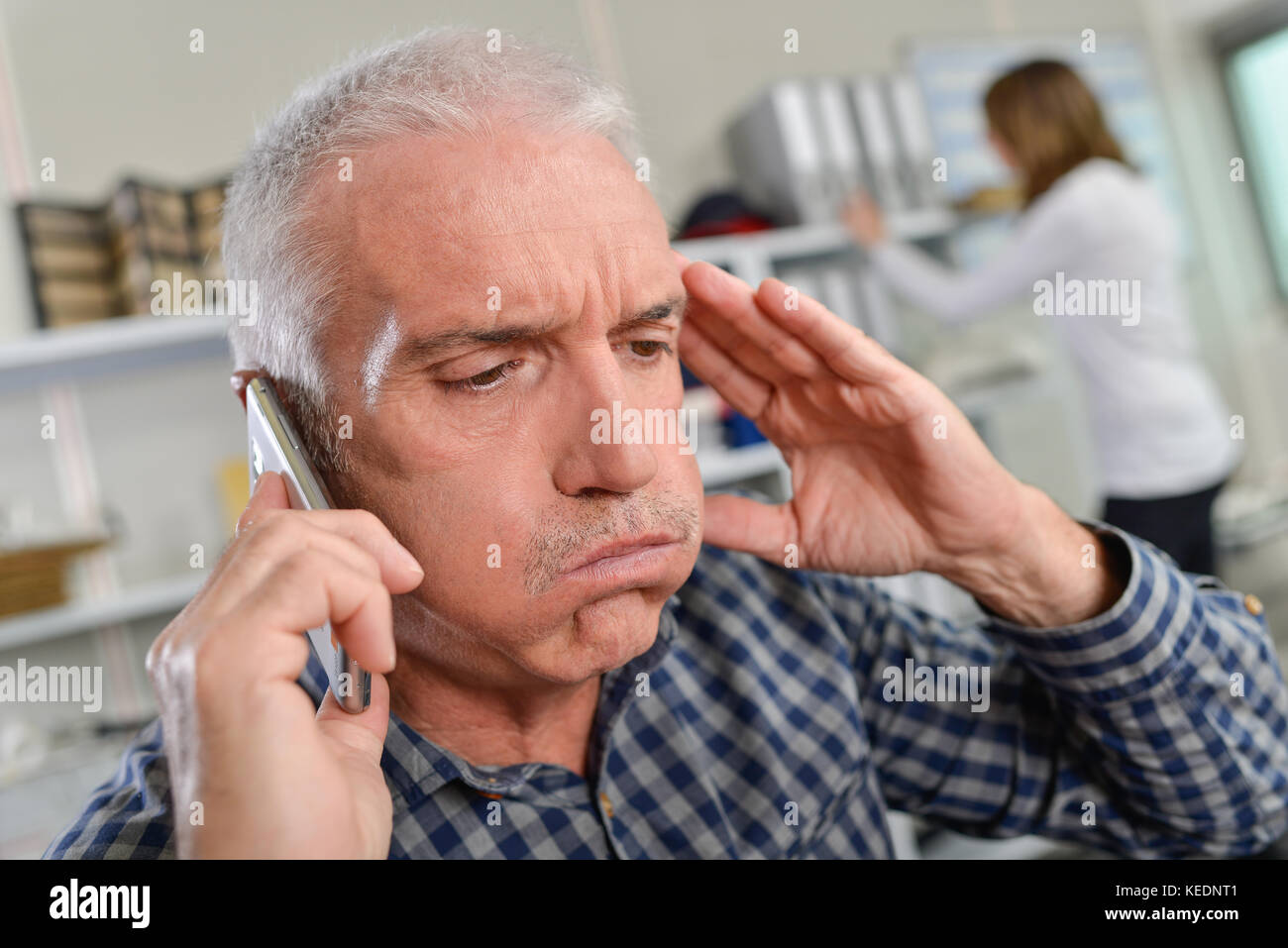 Man on telephone, looking stressed Stock Photo - Alamy