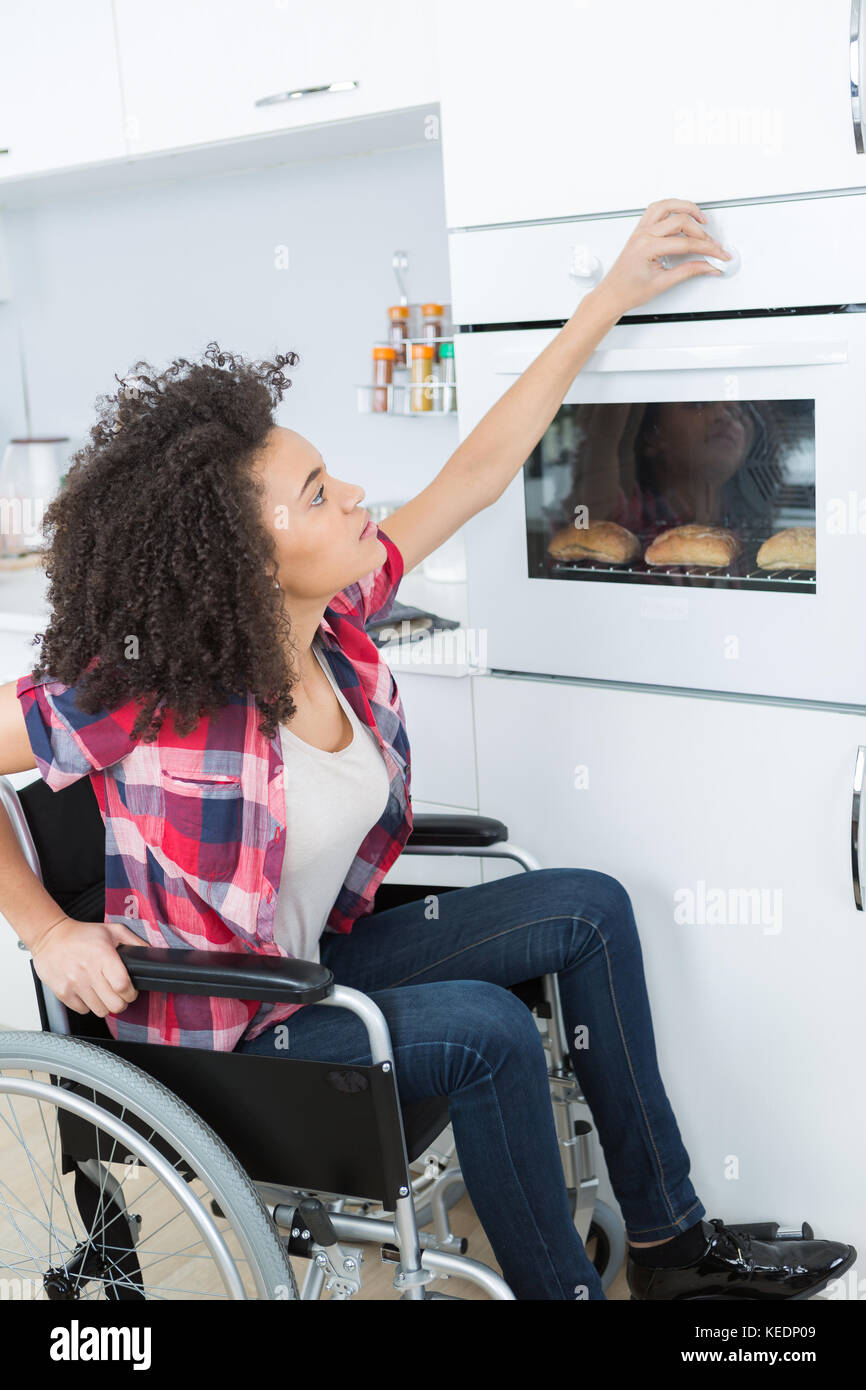 disabled woman baking bread roll in kitchen oven Stock Photo - Alamy