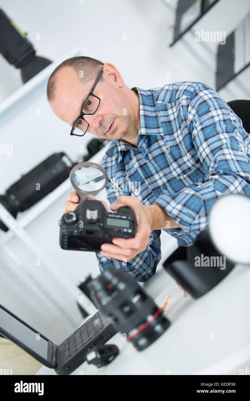 portrait of a focused man fixing camera at his workplace Stock Photo ...