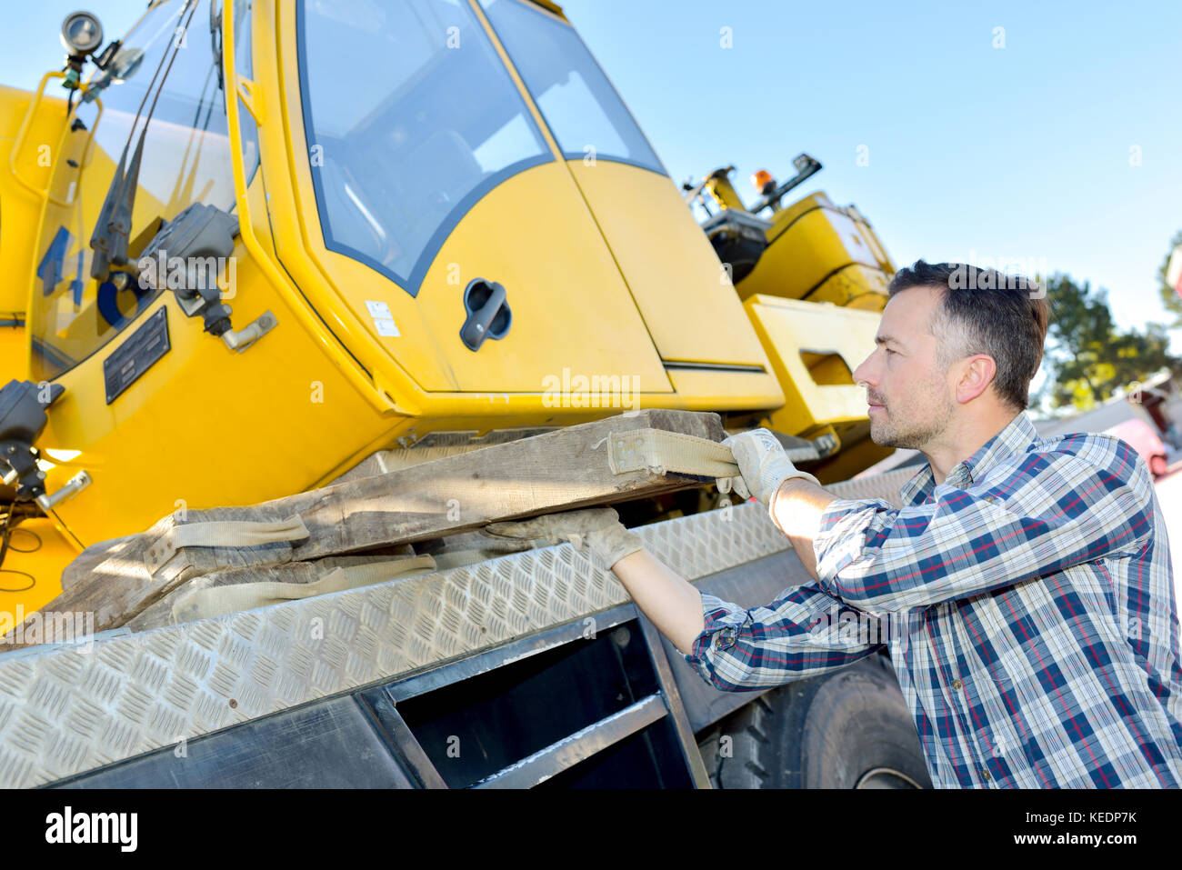 construction worker controls of lifting crane in truck Stock Photo - Alamy