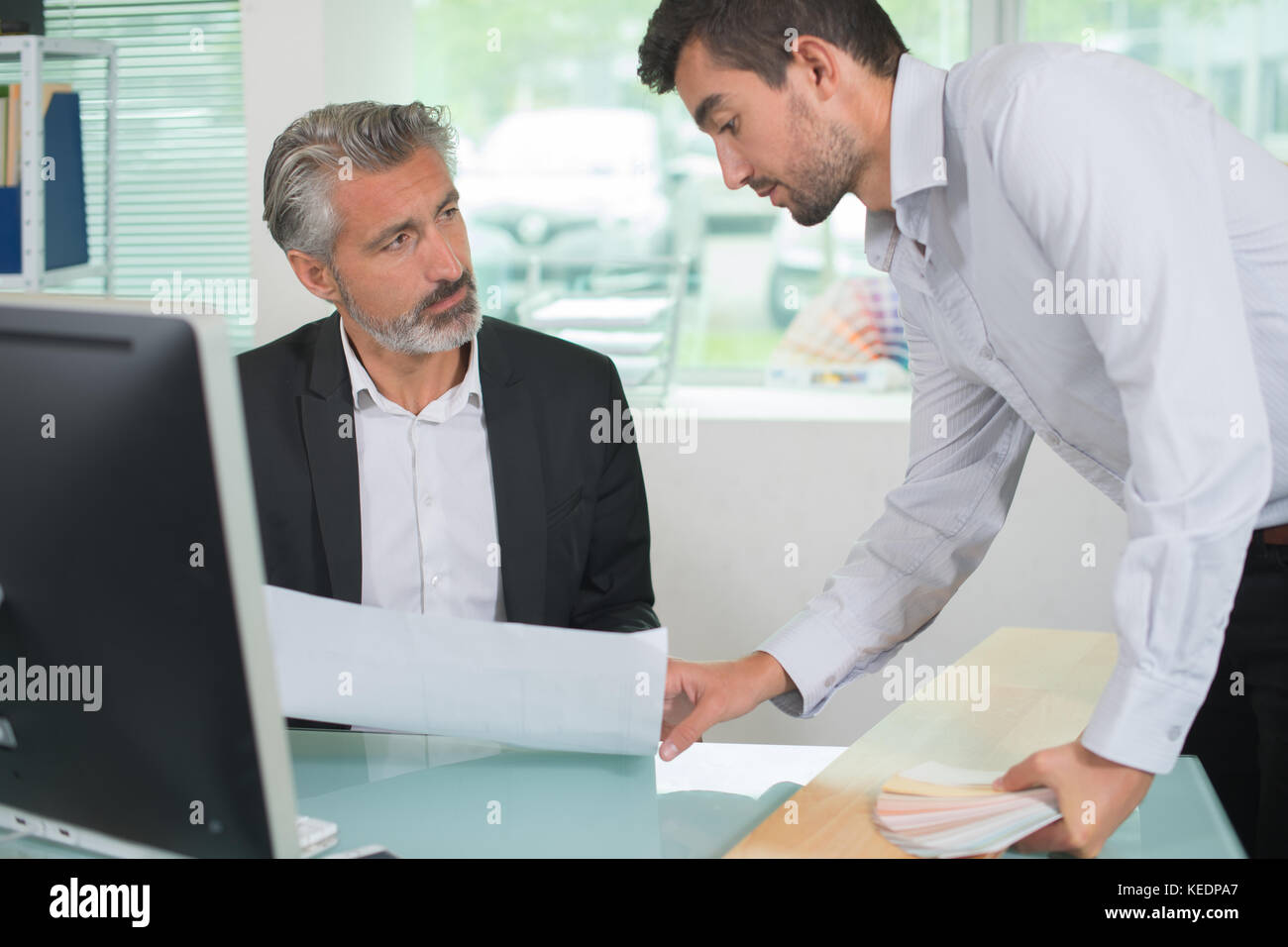 Two businessmen looking at paperwork Stock Photo - Alamy
