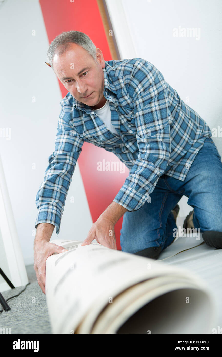 male craftsman fitting carpet on floor Stock Photo - Alamy