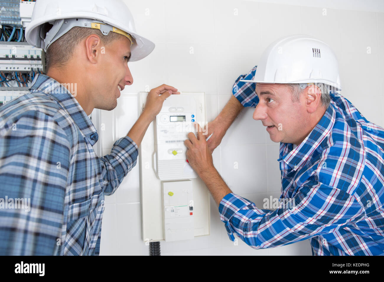 builder showing colleague how to control the heating Stock Photo - Alamy