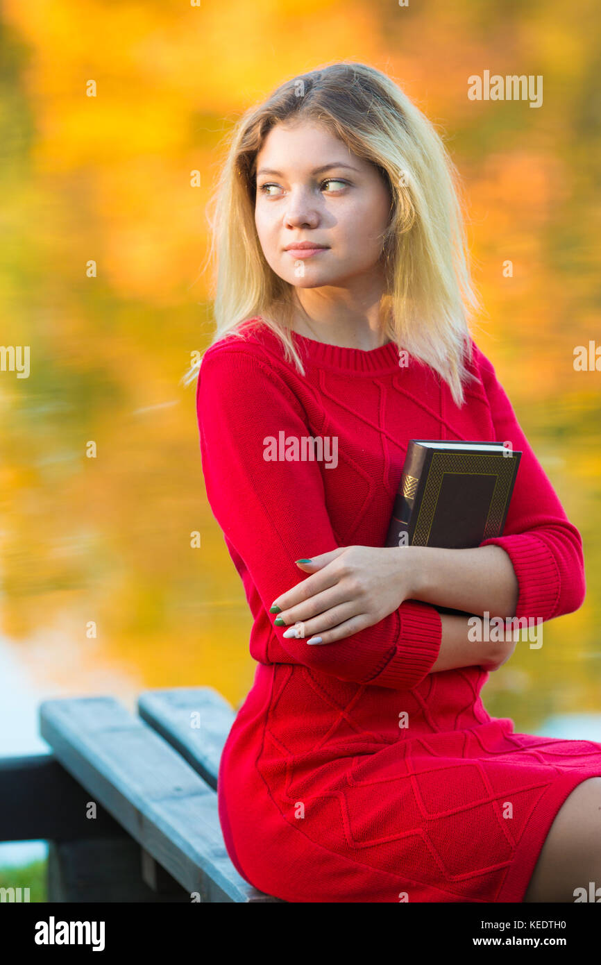 Beautiful Woman with book on Fall Nature Background Stock Photo - Alamy