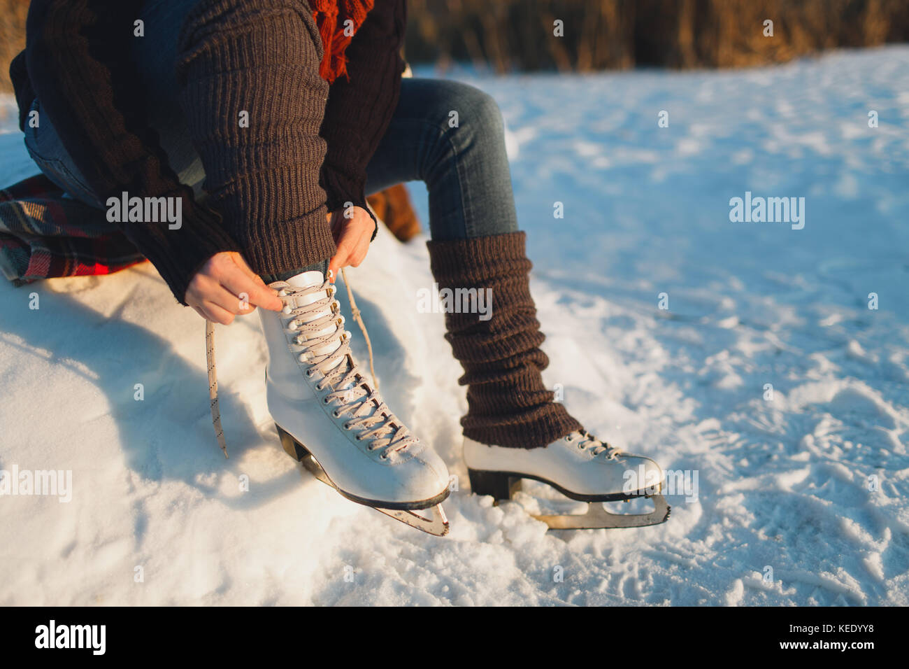 Cropped image of a woman putting ice skates on Stock Photo - Alamy