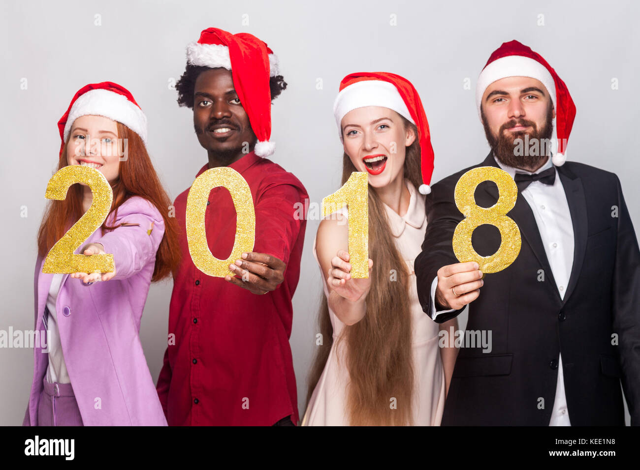 Closeup young adult best friends showing number 2018 at camera. Indoor ...