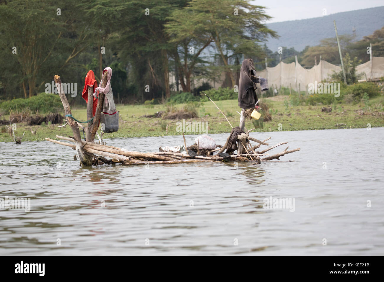 Scarecrows placed on fishing raft to scare hippos Lake Naivasha Kenya ...