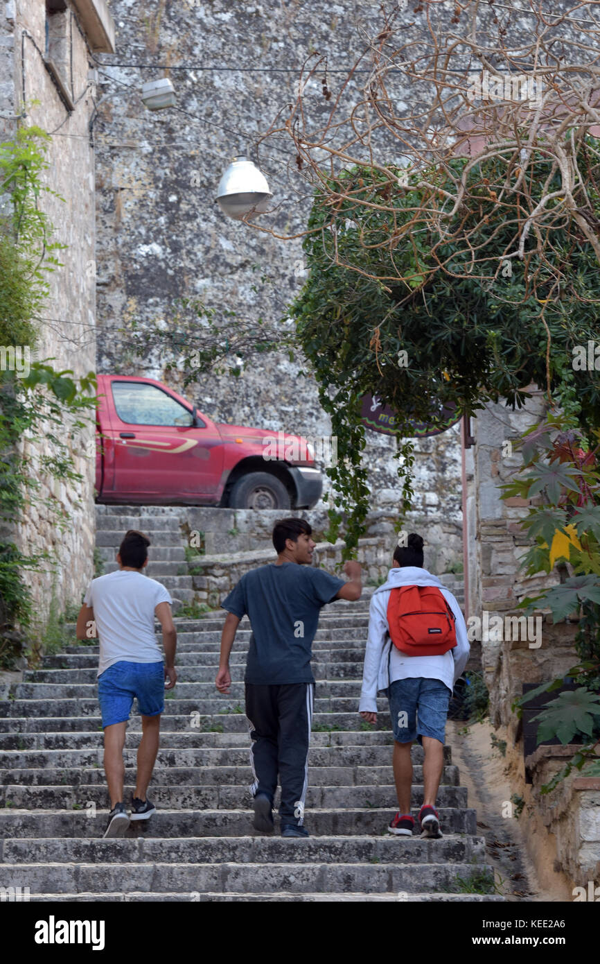 three young men or boys walking up a flight of steps talking with each ...