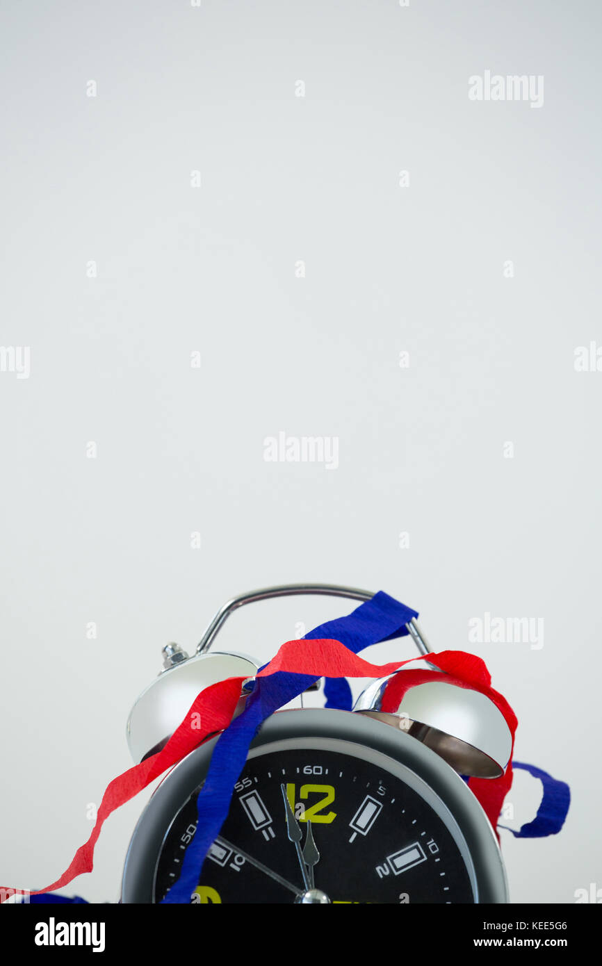 Close-up of alarm clock and streamers against white background Stock ...