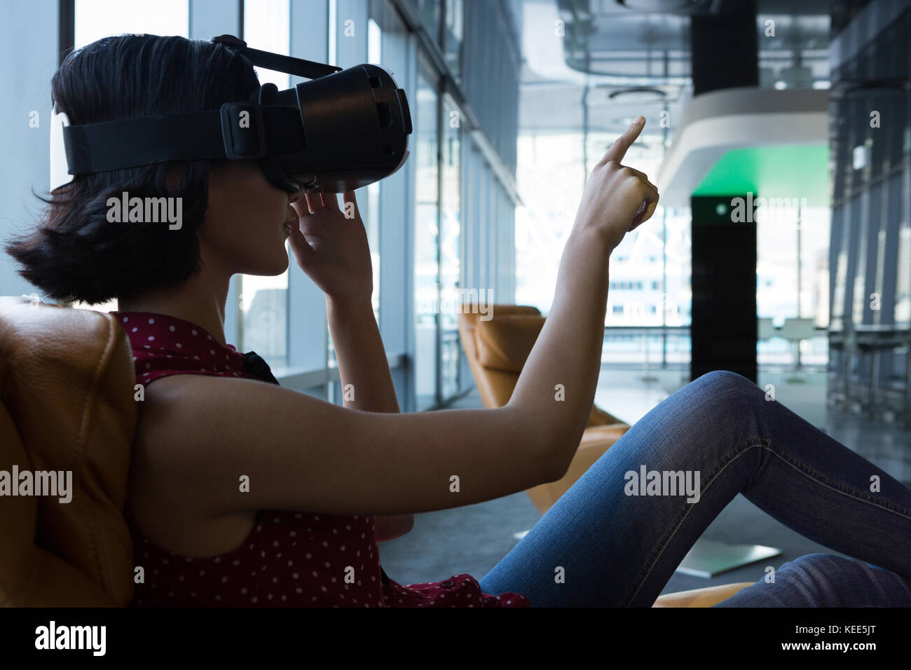 Female executive using virtual reality headset in futuristic office ...