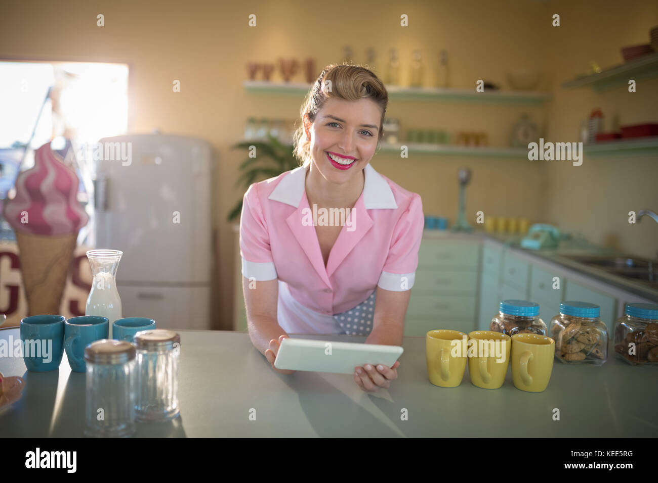 Young waitress using digital tablet in restaurant Stock Photo - Alamy