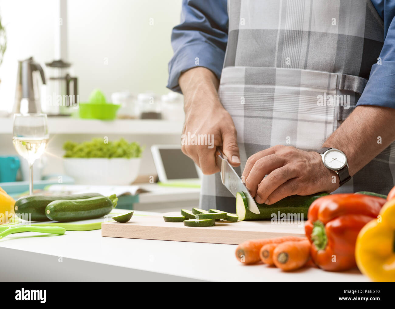 Man preparing lunch in the kitchen, he is slicing fresh healthy ...