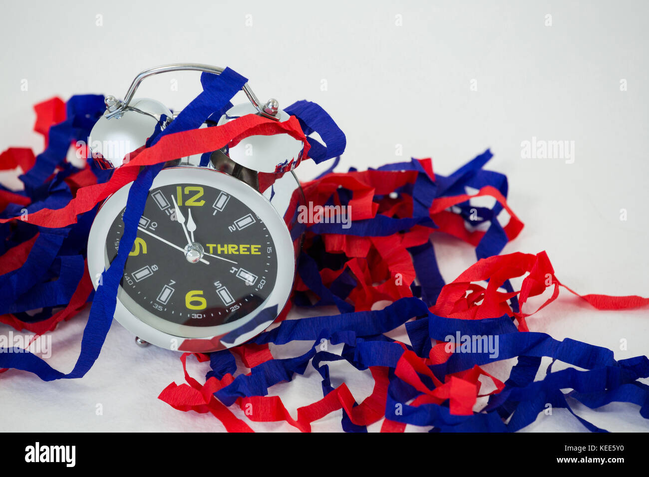 Close-up of alarm clock and streamers against white background Stock ...