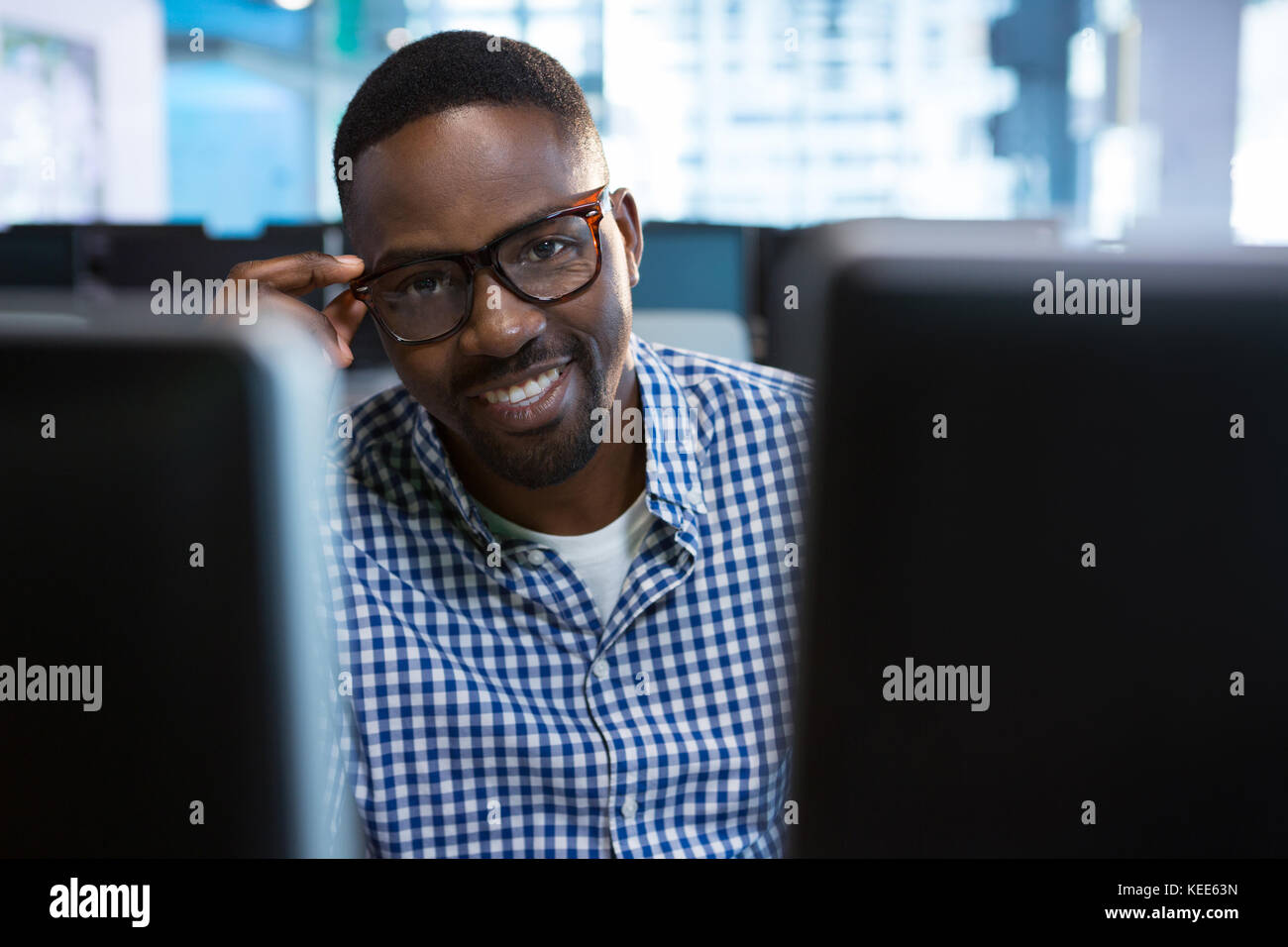 Portrait of computer engineer sitting at desk in office Stock Photo - Alamy