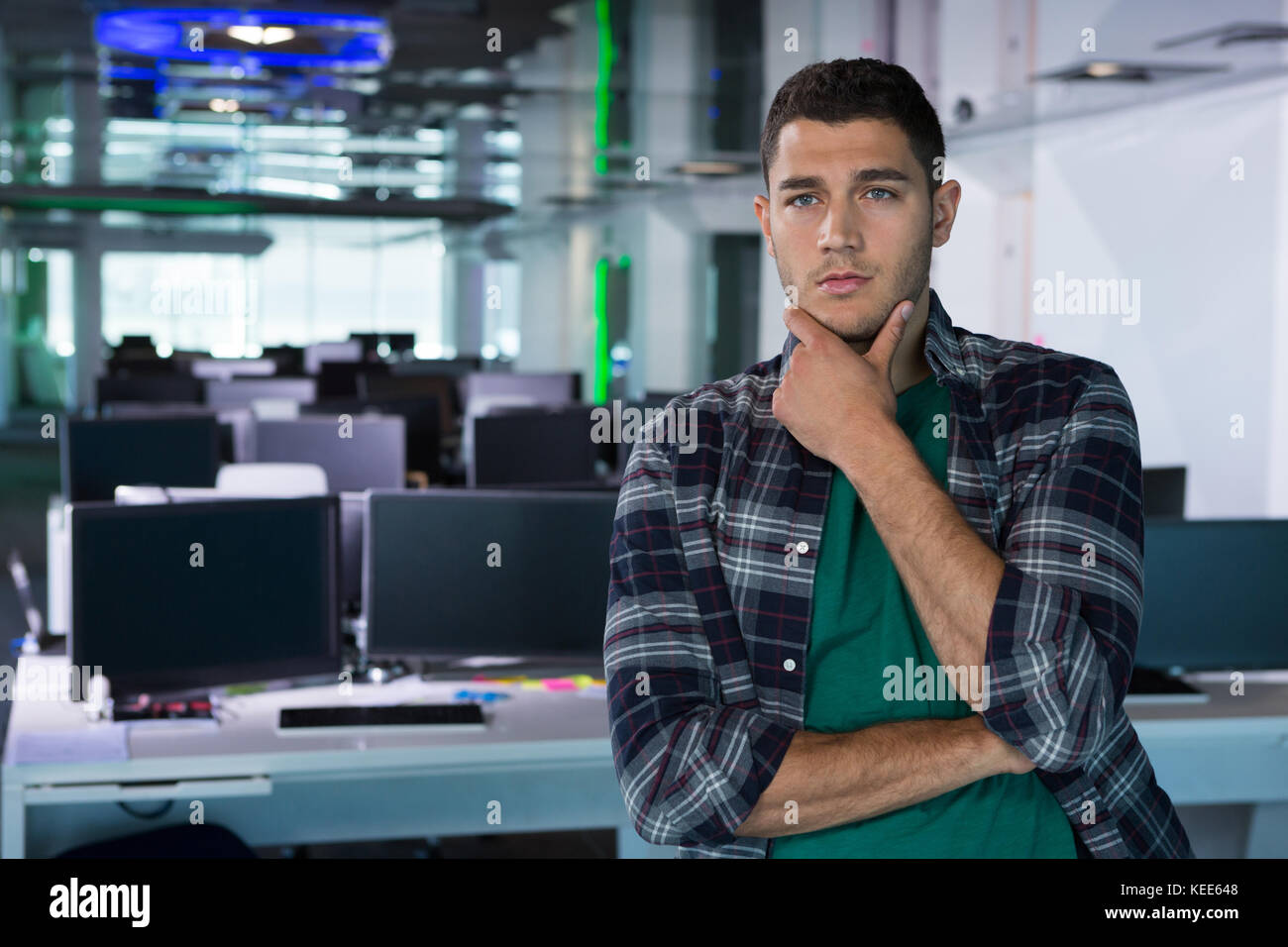 Thoughtful male executive standing in office Stock Photo - Alamy