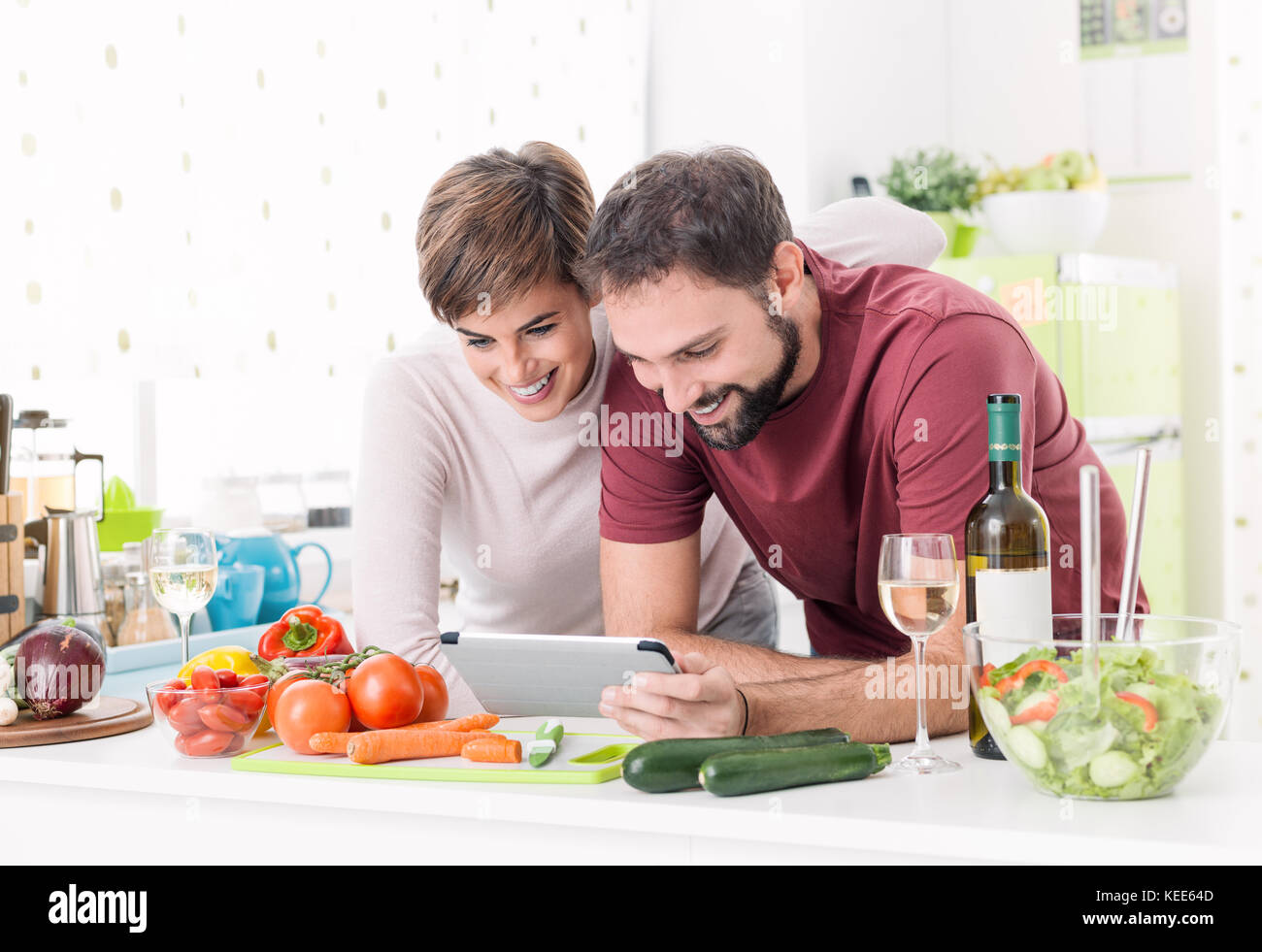 Young smiling couple cooking together at home, they are preparing ...