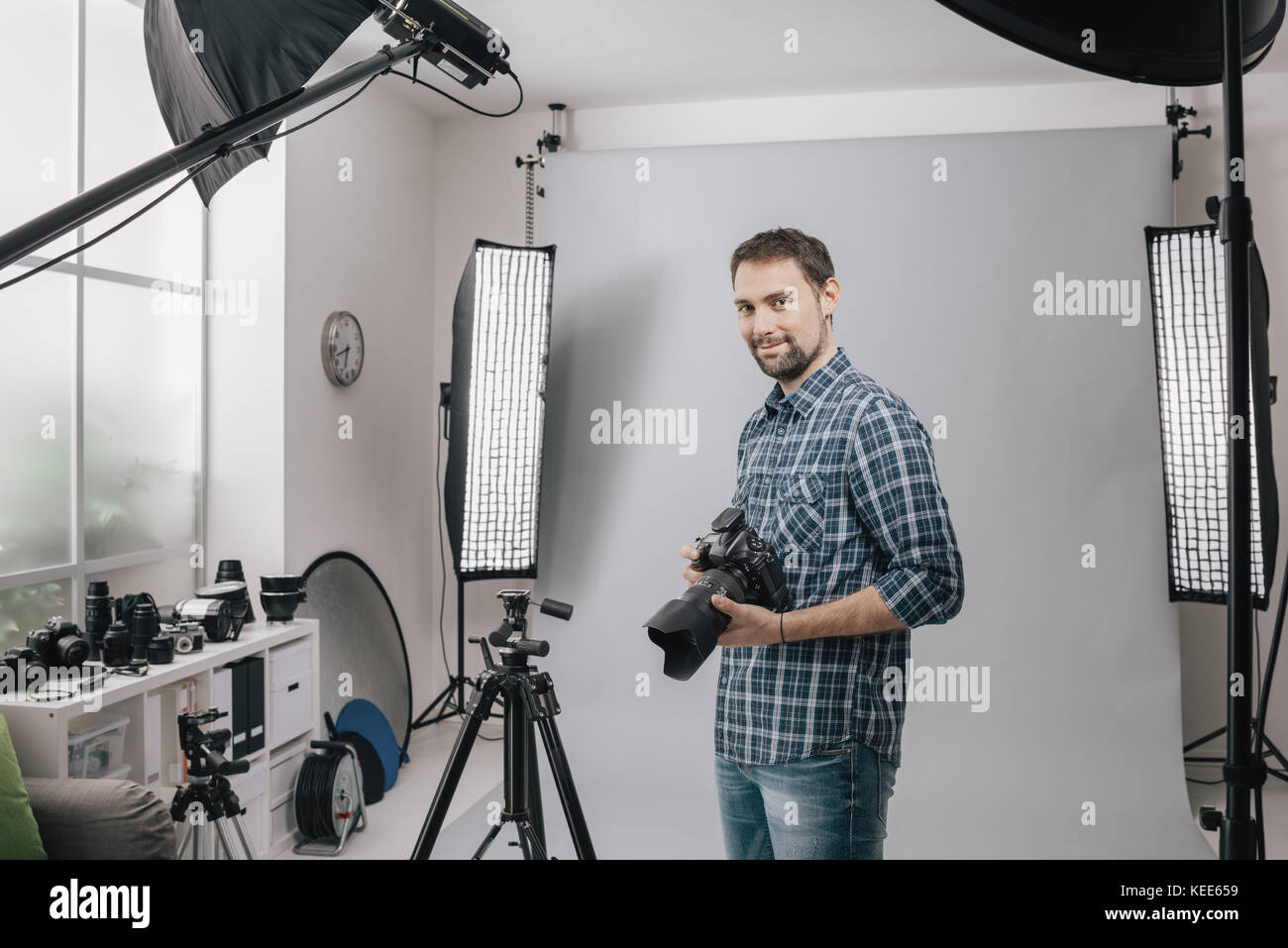 Professional photographer posing in the studio and holding a digital ...