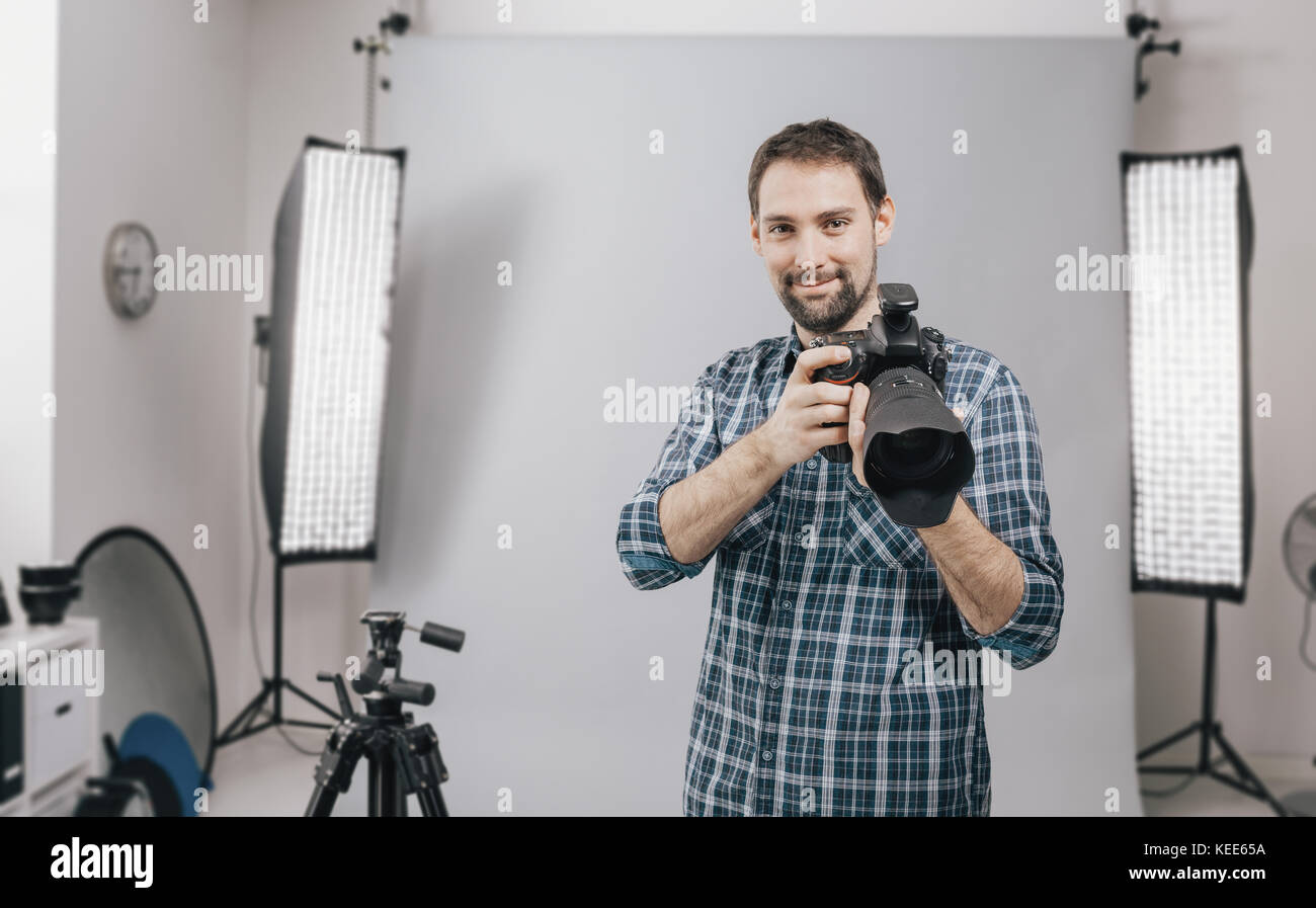 Professional photographer posing in the studio and holding a digital ...